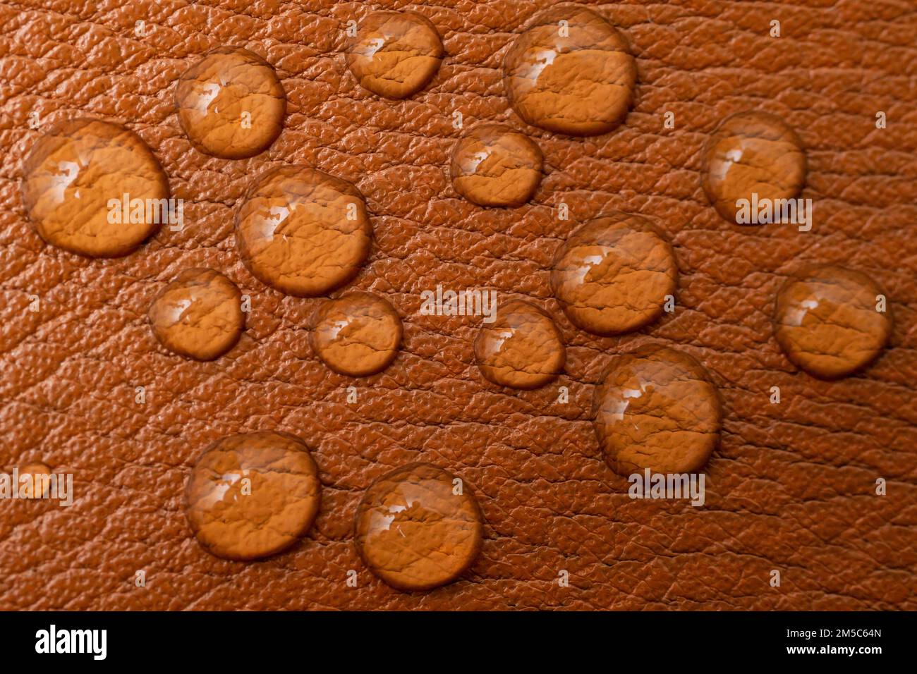 Round water drops on brown leather texture, soft focus close up pattern ...
