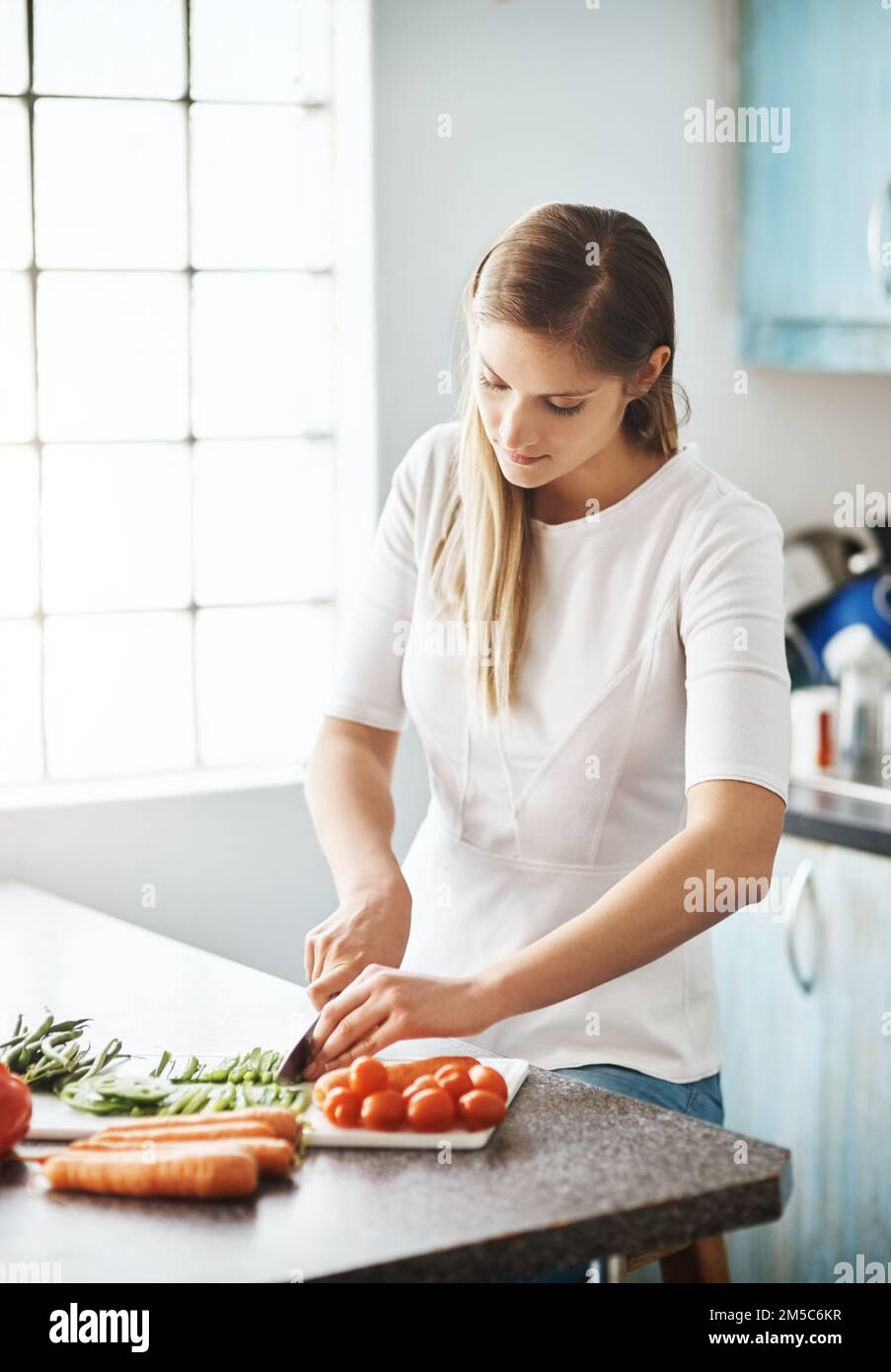 I keep a clean diet. a young woman preparing a healthy meal at home ...