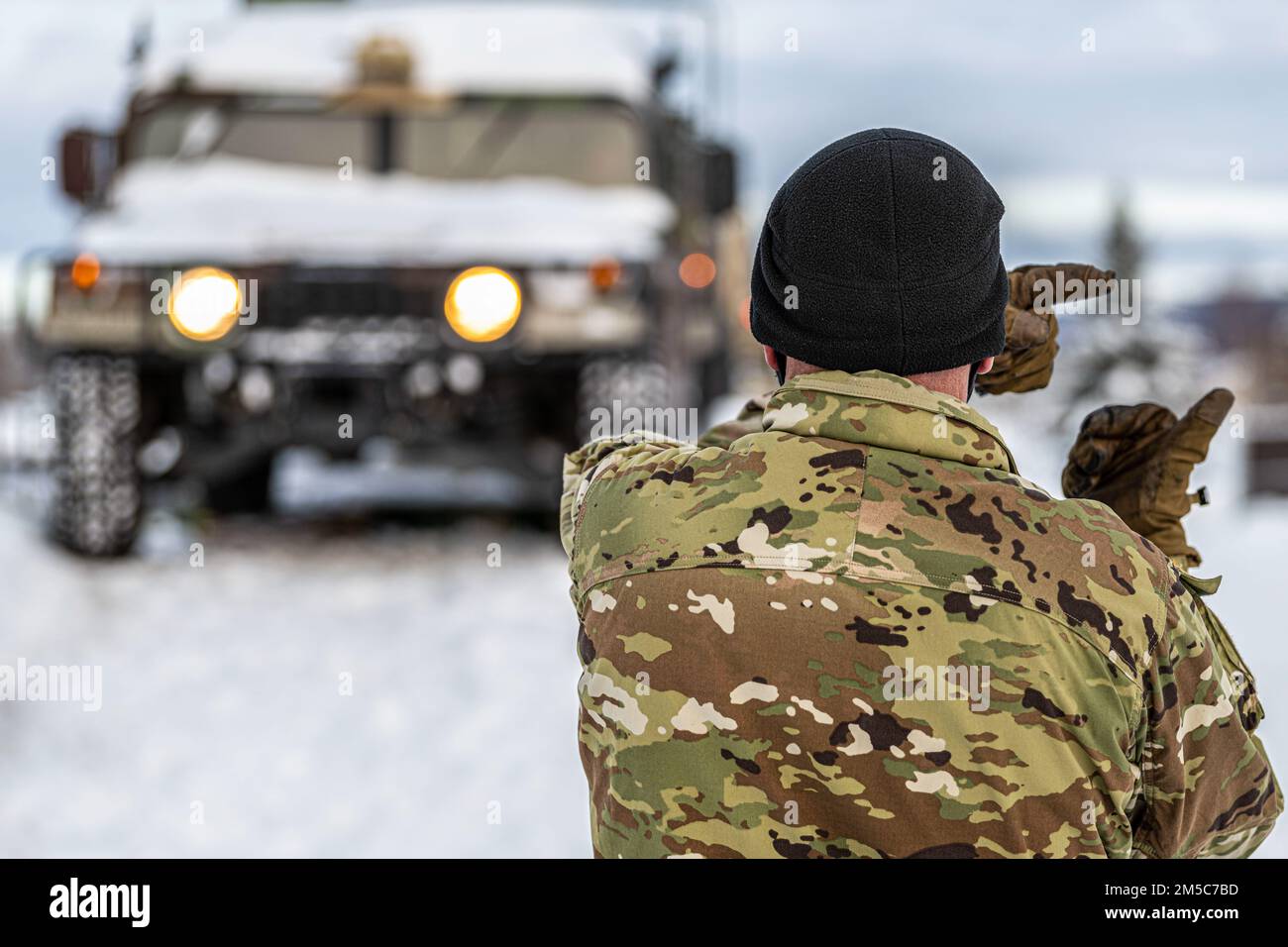 A U.S. Army soldier guides a Humvee as it is unloaded in preparation ...