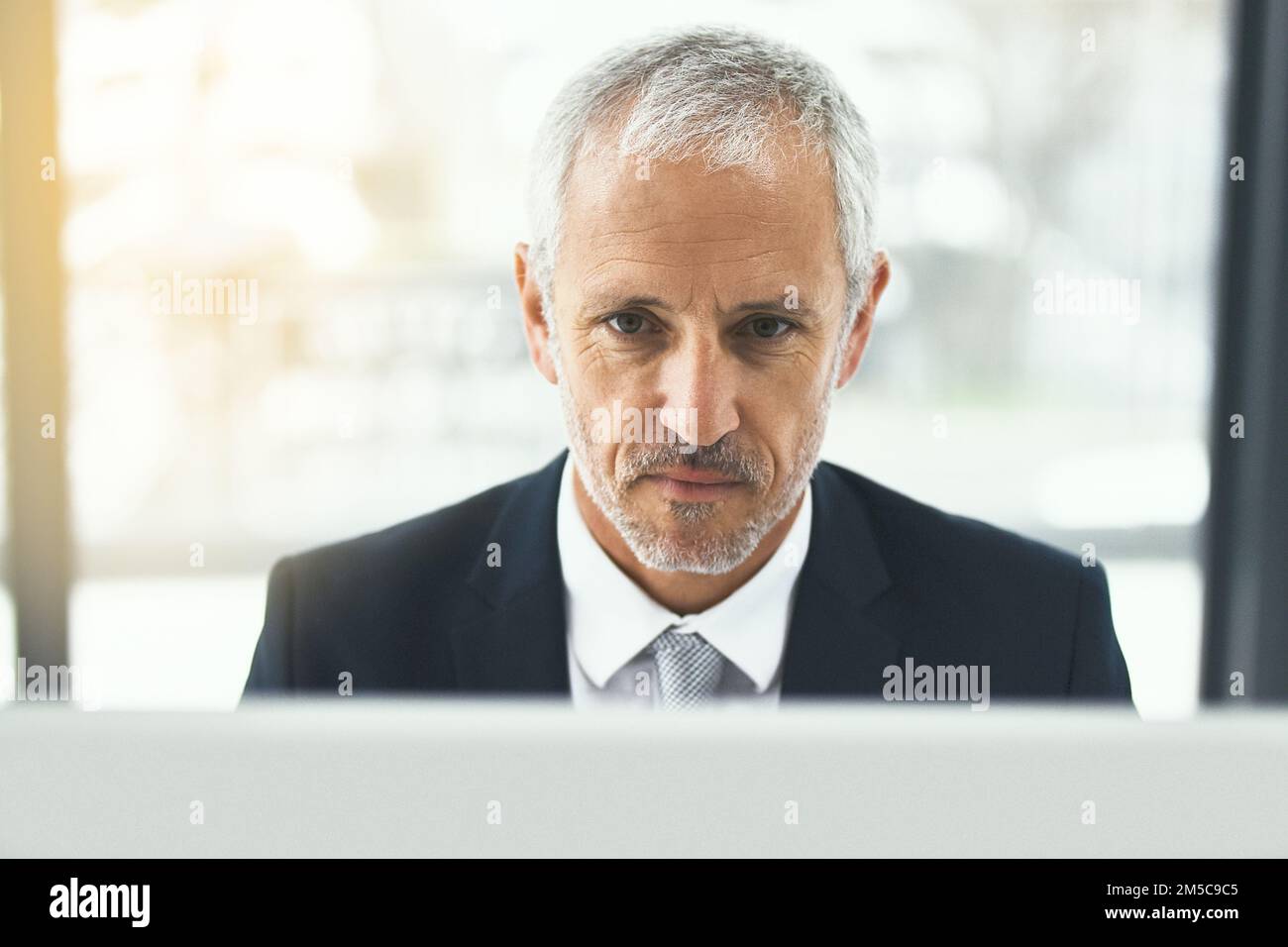 Keeping abreast of the newest business trends. a focused mature businessman working on his ...