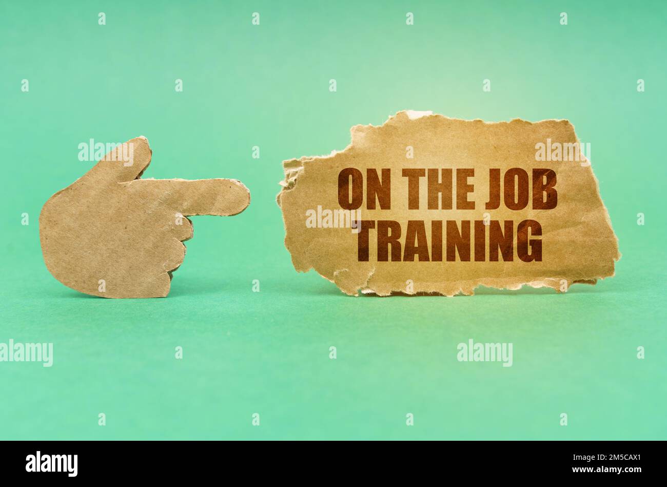 Business and education concept. On a green surface, a cardboard hand ...