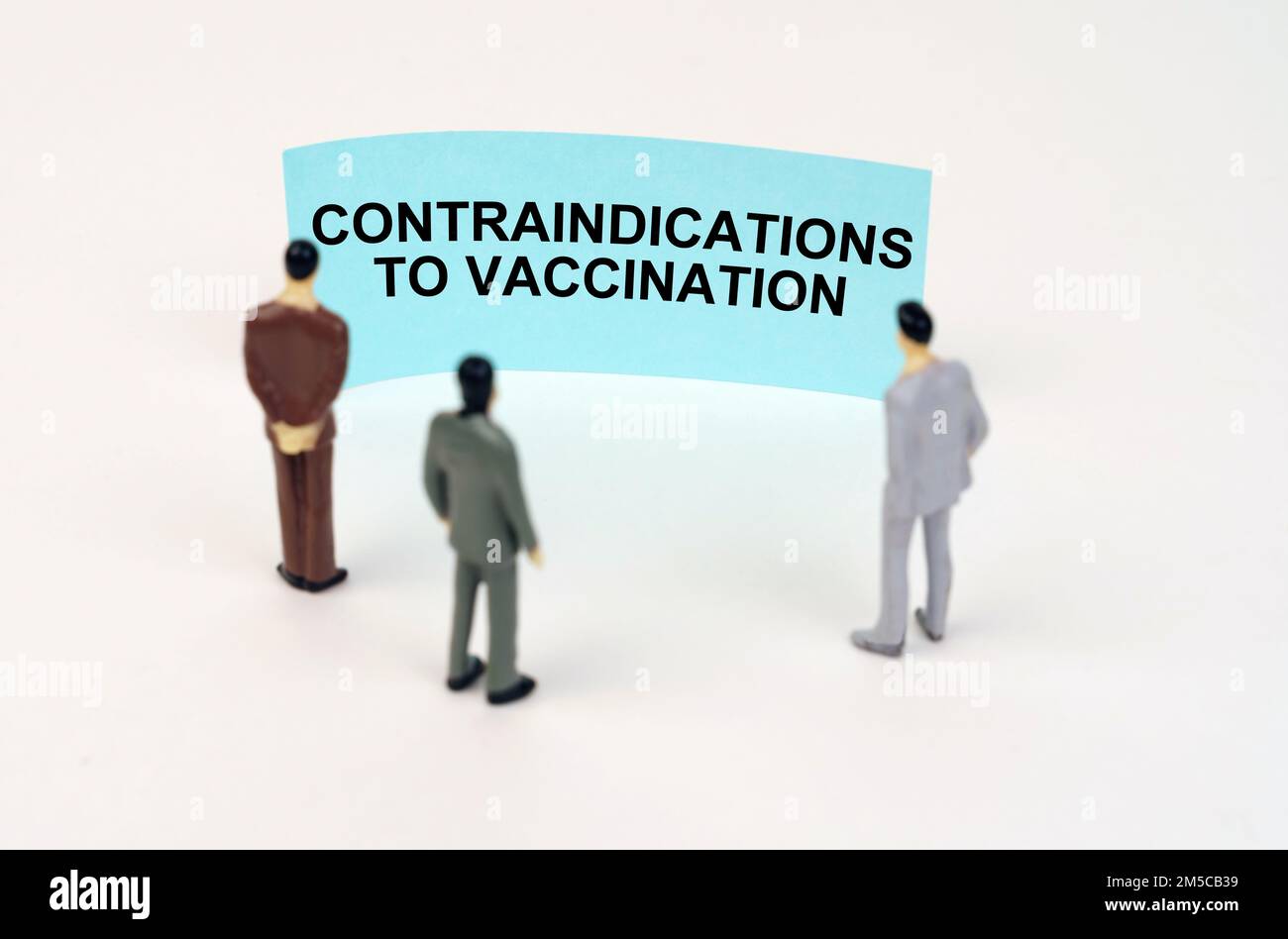 Medical concept. Miniature figures of people stand in front of a blue ...