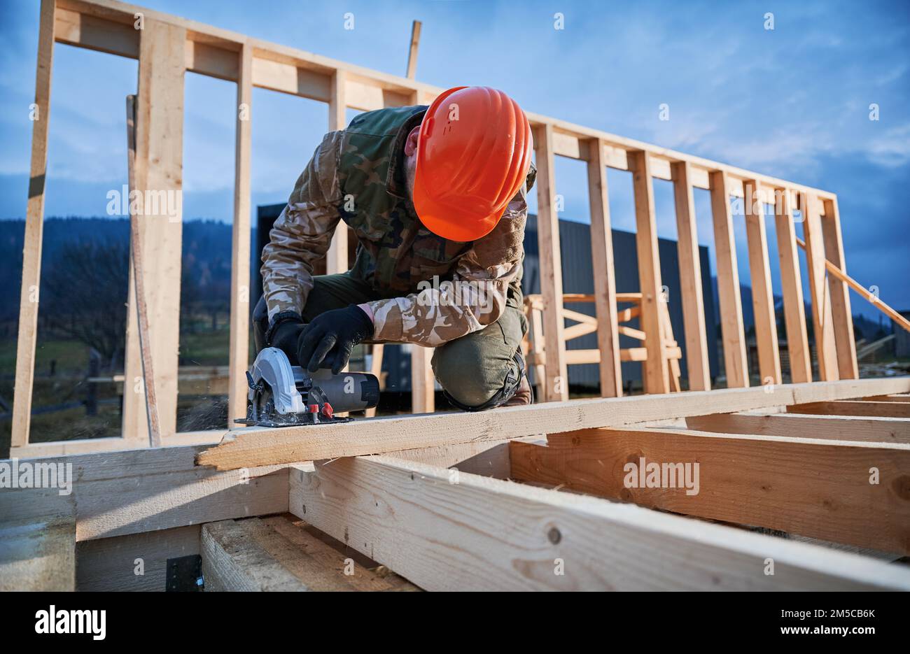Carpenter using circular saw for cutting wooden plank. Man worker ...