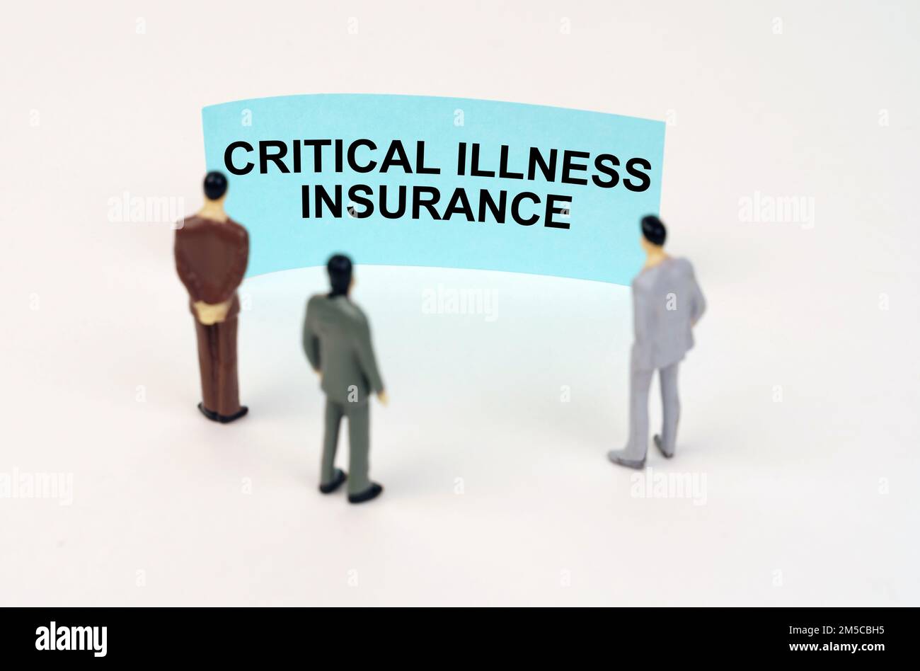 Medical concept. Miniature figures of people stand in front of a blue ...