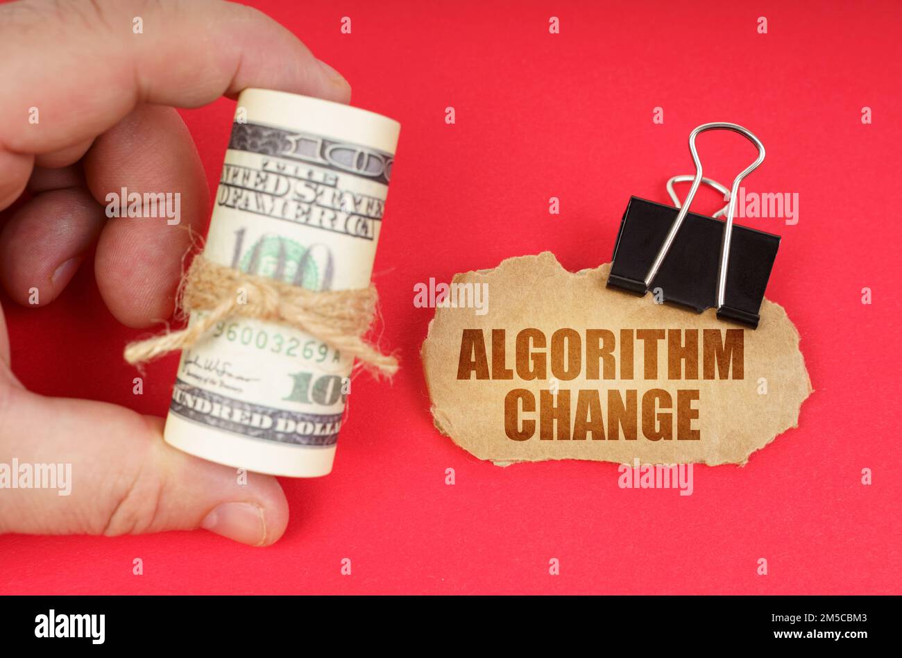 Business concept. The man has dollars in his hands, on a red surface ...