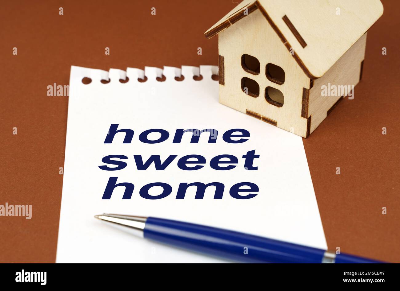 Business concept. On a brown surface is a house, a pen and a notepad ... Business concept. On a brown surface is a house, a pen and a notepad ...