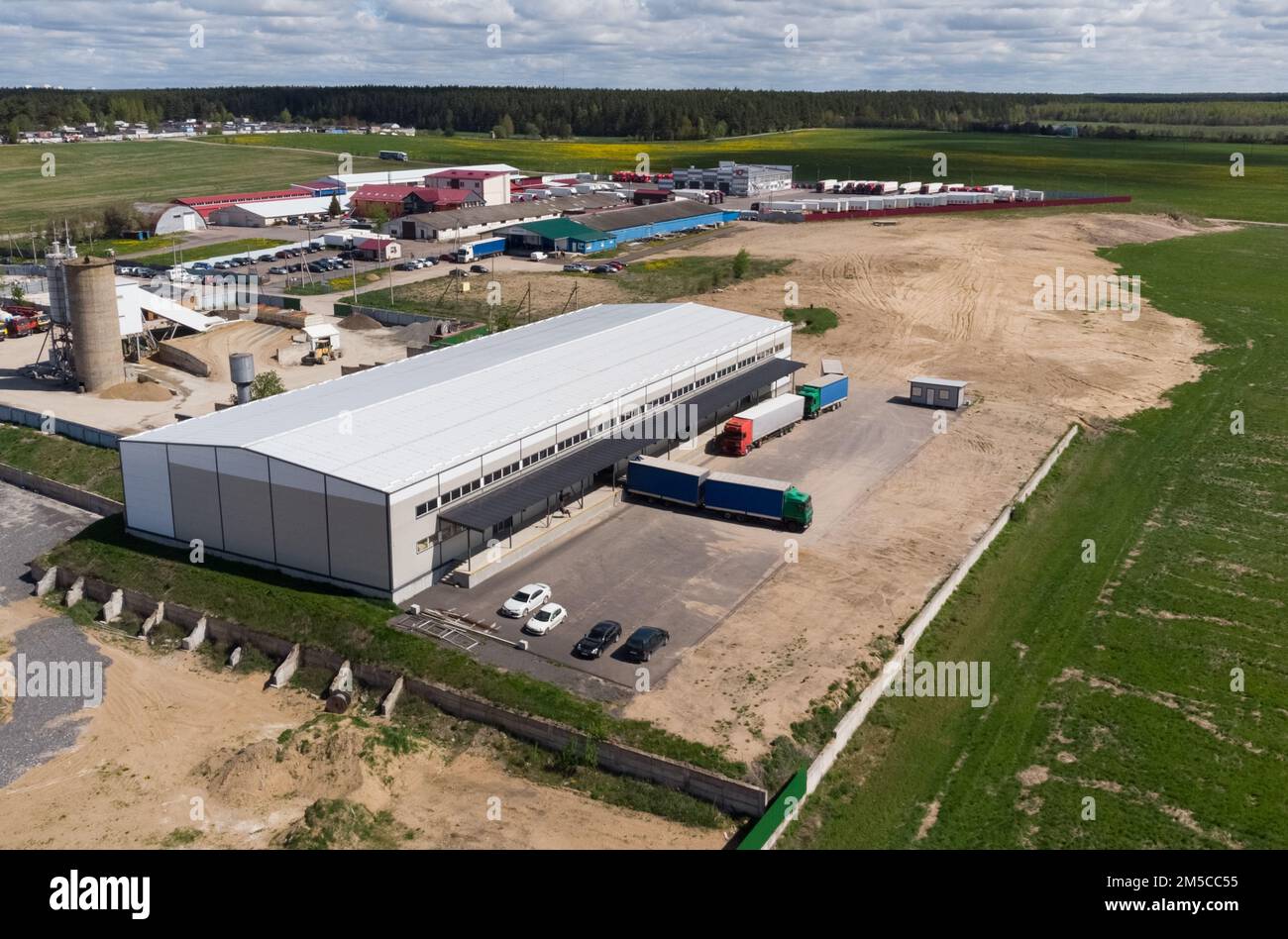 Trucks are at loading and unloading operations in warehouses. View from ...