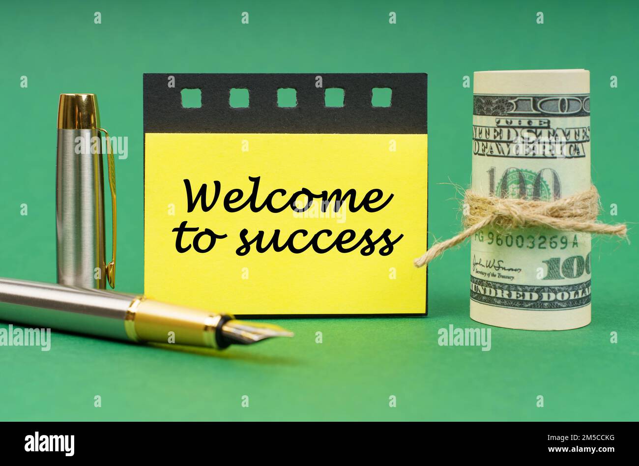 Business concept. On a green surface, a pen, dollars, a notepad and ...
