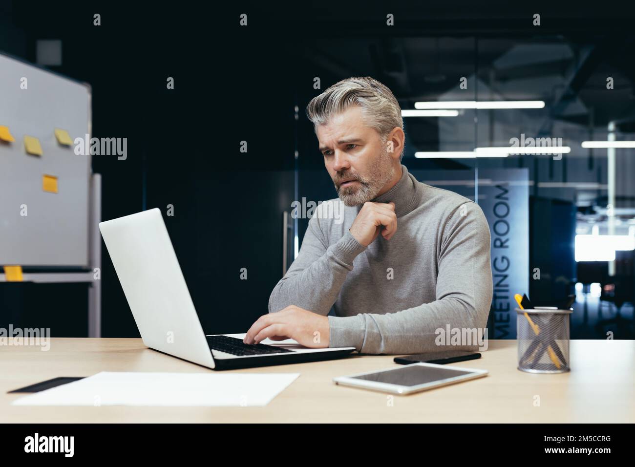 Serious thinking businessman inside office at work with laptop, senior ...