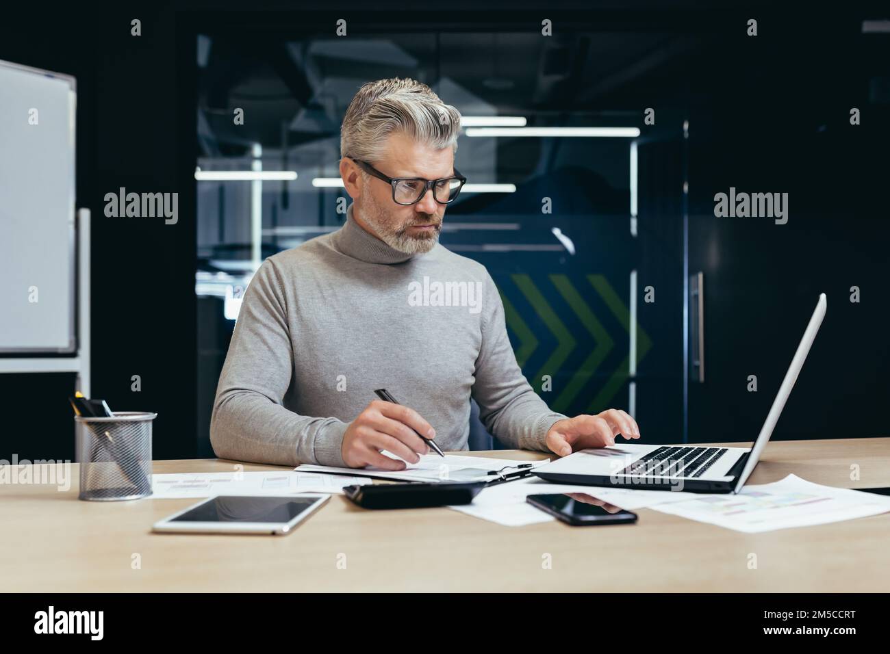 Serious thinking businessman inside office at work with laptop, senior ...