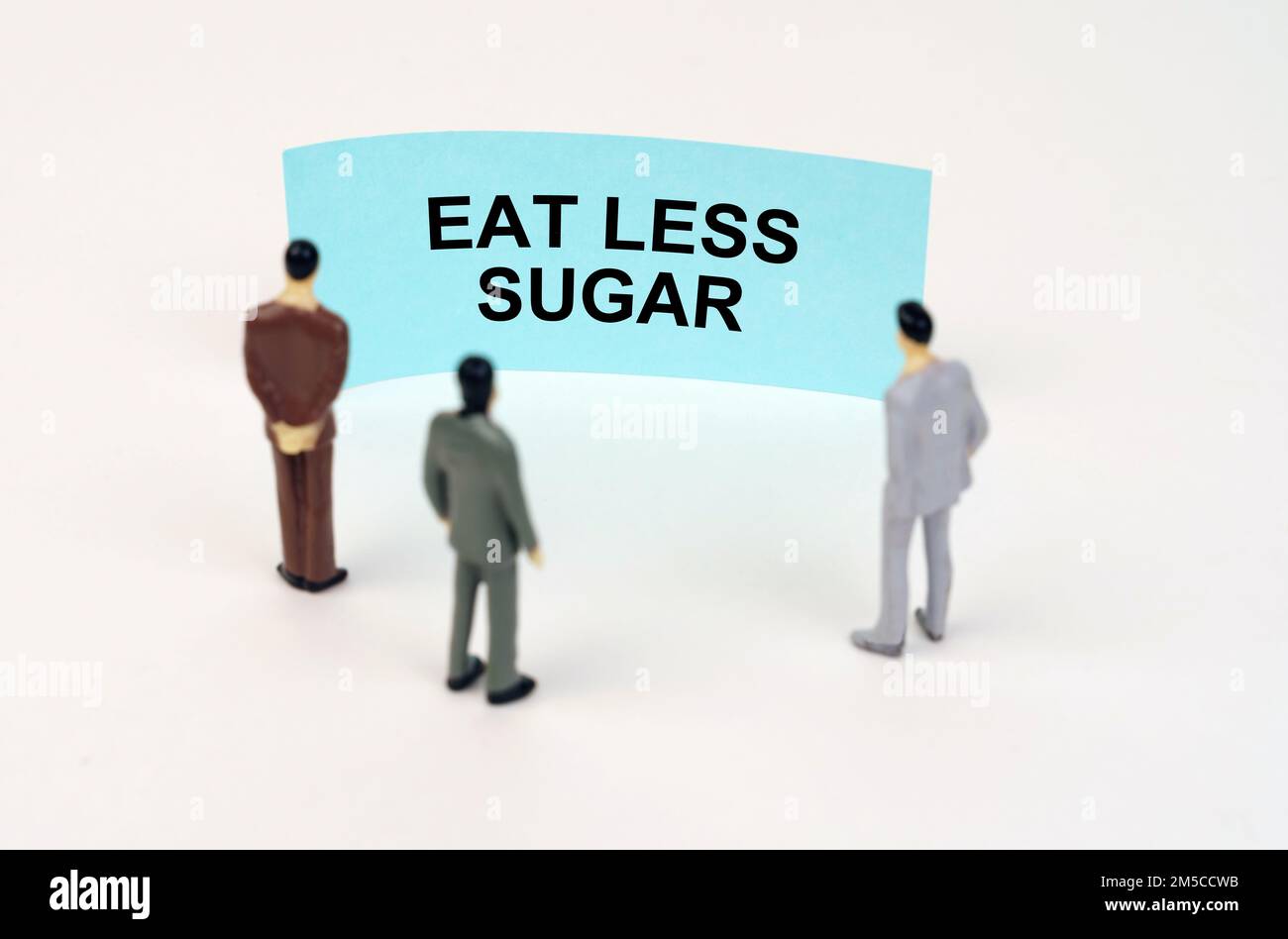 Medical concept. Miniature figures of people stand in front of a blue ...