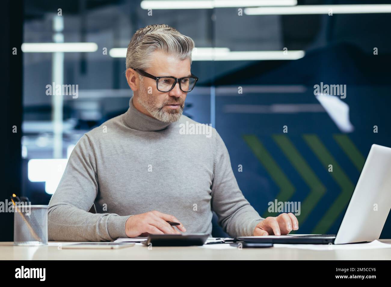 Serious thinking businessman inside office at work with laptop, senior ...