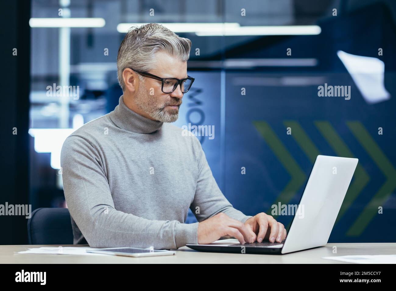 Serious thinking businessman inside office at work with laptop, senior ...