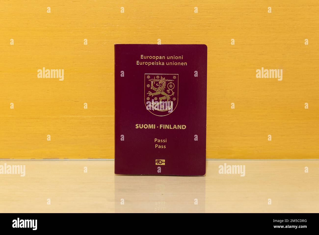 Finnish passport on a wooden counter with yellow background Stock Photo ...