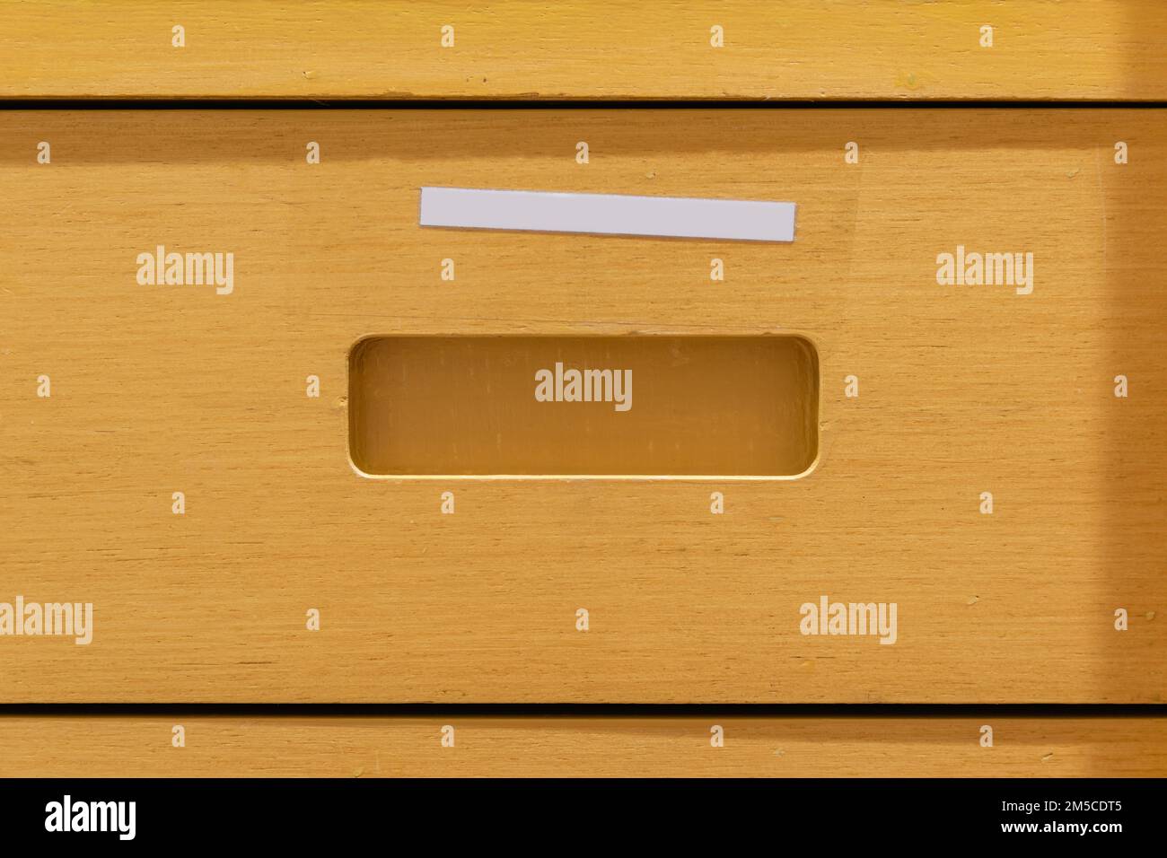 Wooden drawer with blank white label Stock Photo - Alamy