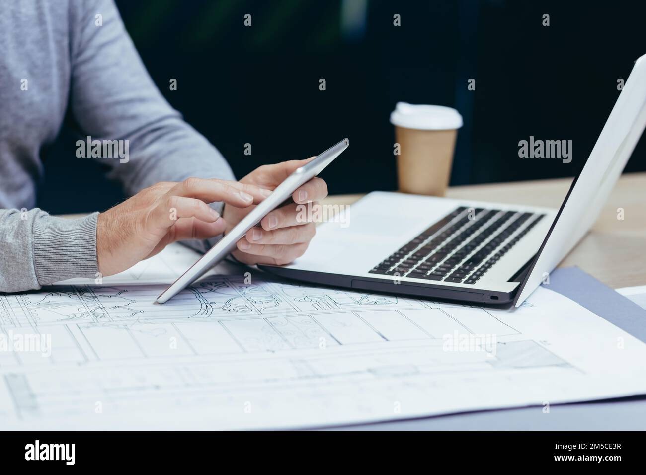 Close-up photo of hands of male designer architect working with tablet ...