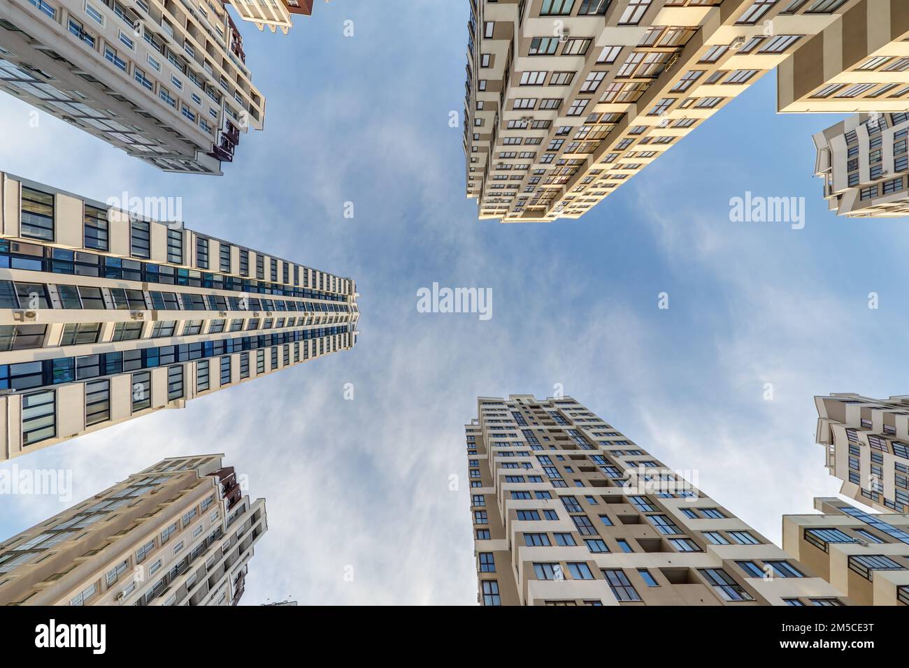 view up from ground to blue sky among skyscrapers, look at house from ...