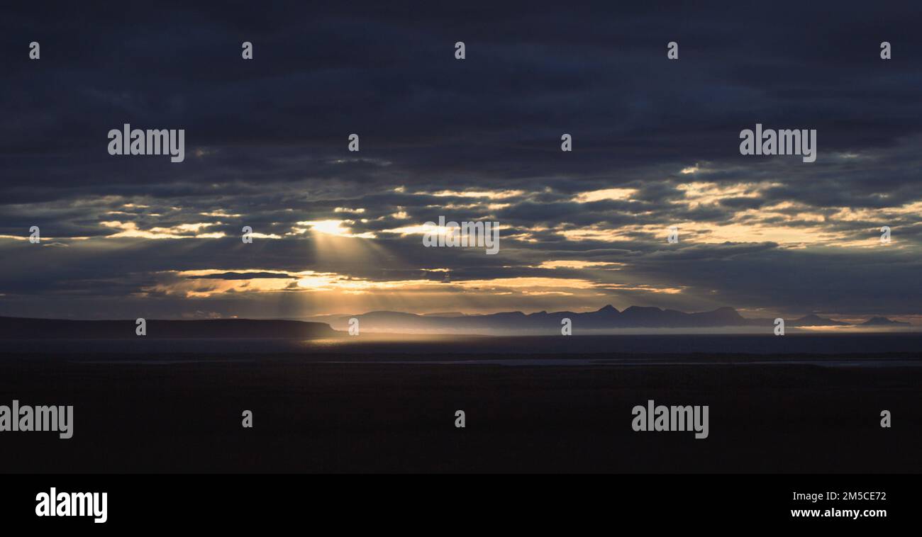 Sun shining through heavy clouds landscape photo Stock Photo - Alamy