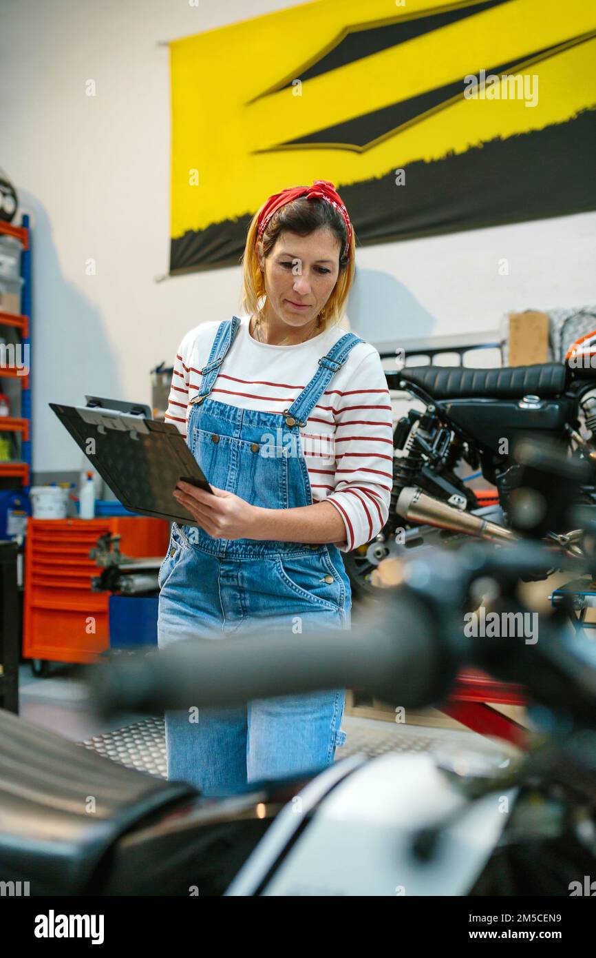 Mechanic reviewing damages in motorbike on workshop Stock Photo - Alamy