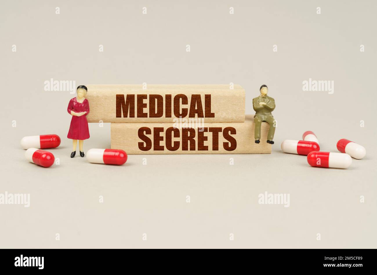 Medical concept. Next to the miniature figurines of people are tablets ...