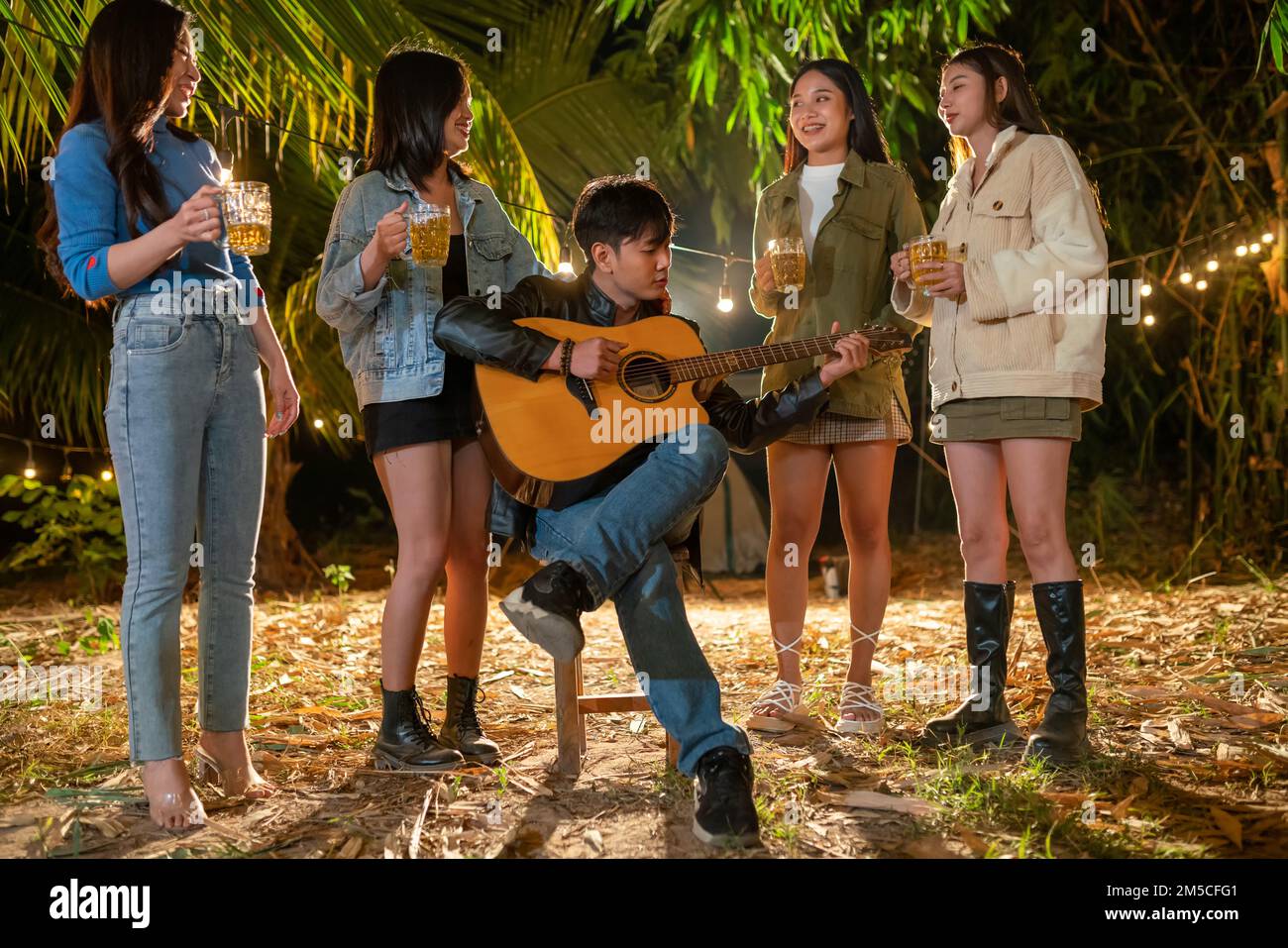 A group of friends at a party enjoy playing guitar at a party Stock ...