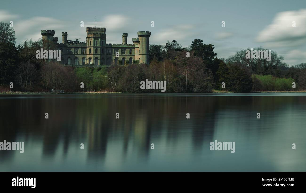 A long exposure shot of the Castle of Eastnor reflected in the lake ...