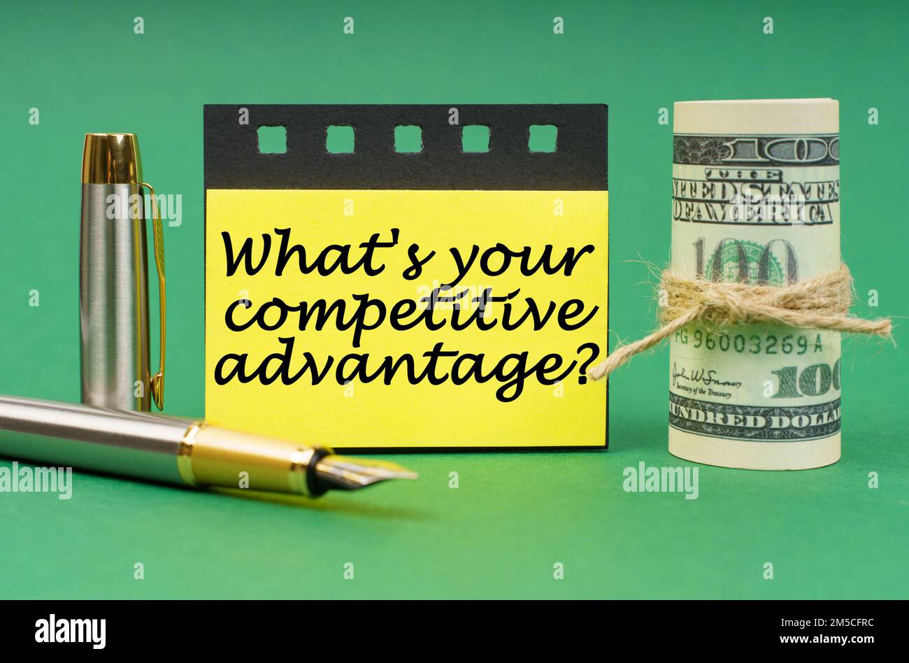 Business concept. On a green surface, a pen, dollars, a notepad and ...