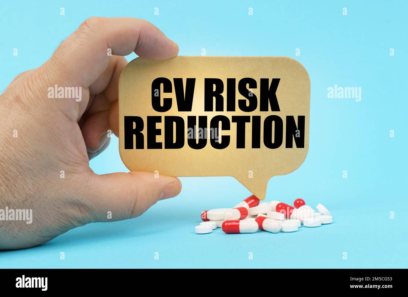 Medical concept. On a blue surface are pills in a persons hand, a sign ...