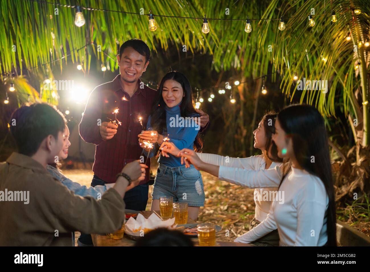 young party people happily hold sparkles in celebration Stock Photo - Alamy