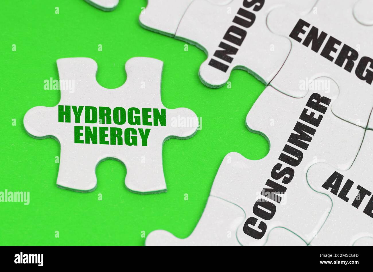 Energy concept. On a green surface there are white puzzles with ...