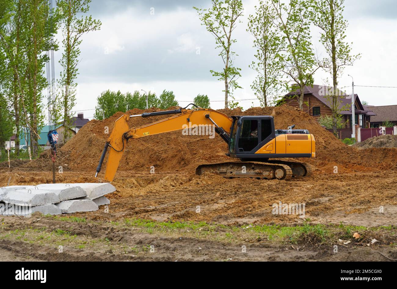 Building concept. An excavator is digging a pit for a house Stock Photo ...