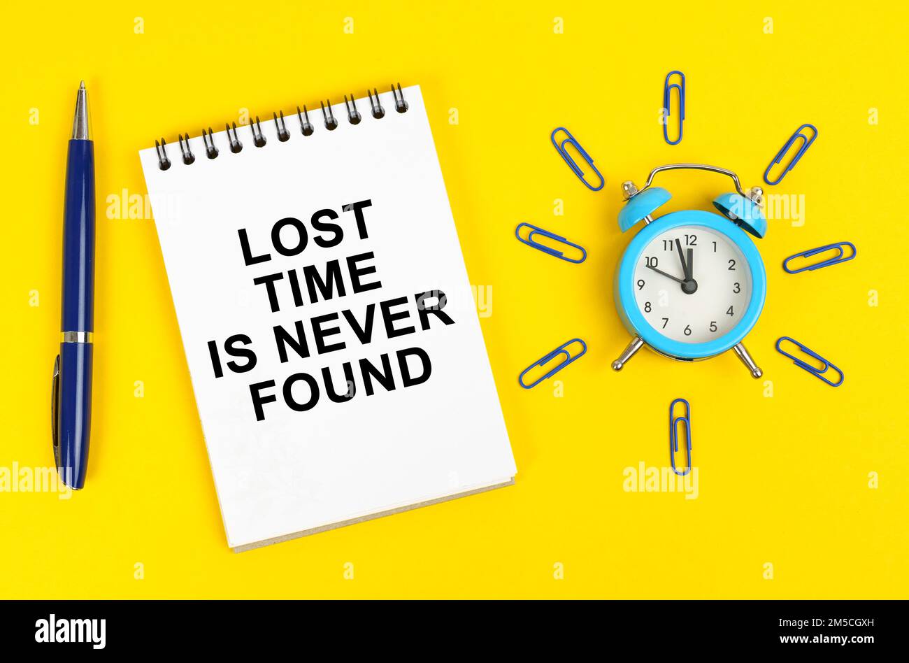 Business concept. On a yellow surface there is an alarm clock, a pen ...