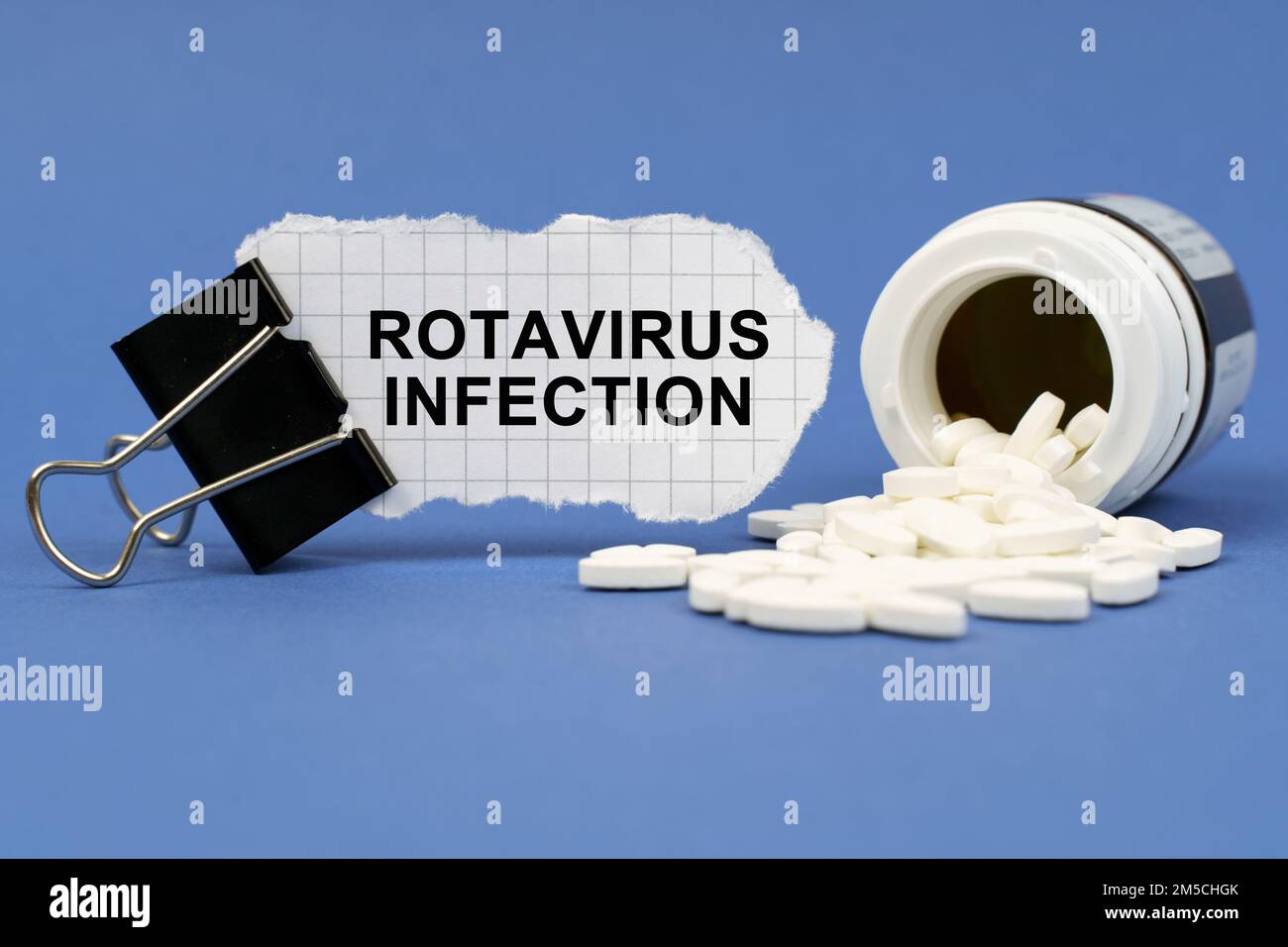 Medicine concept. On the blue surface lies a jar of pills and a clip ...