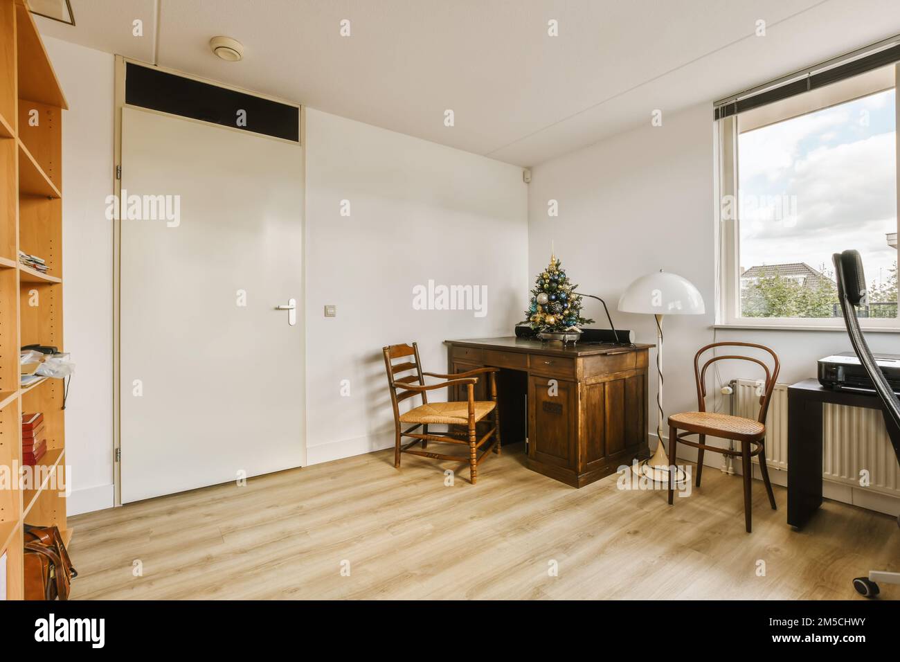 a small room with a desk, chair and computer on the floor in front of a ...