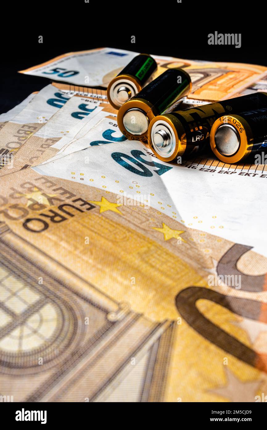 Close up, 4 AA batteries laying on stack of 50 Euro banknotes ...
