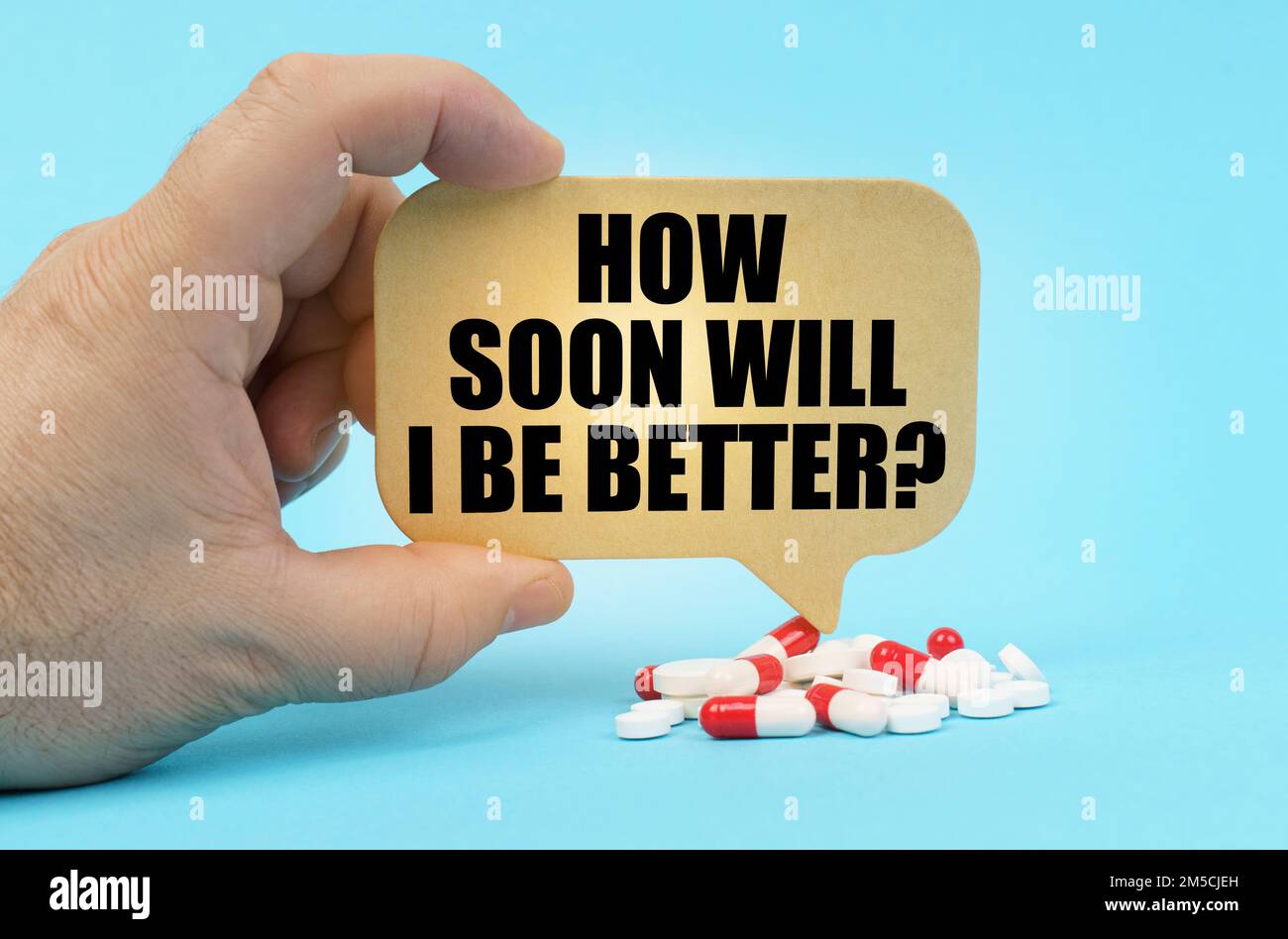 Medical concept. On a blue surface are pills in a persons hand, a sign ...