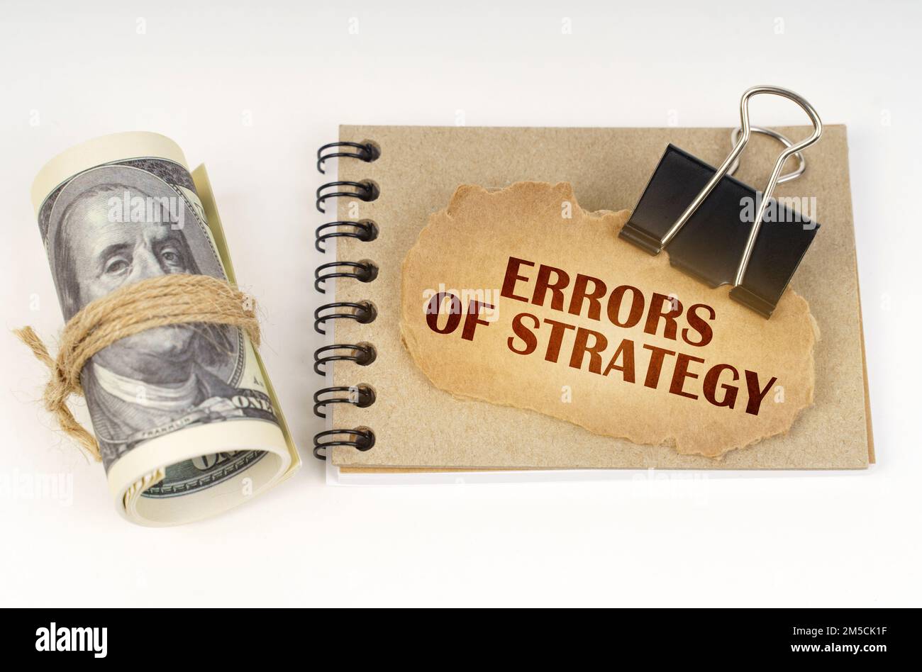 Business and finance concept. On a white surface are twisted dollars, a ...