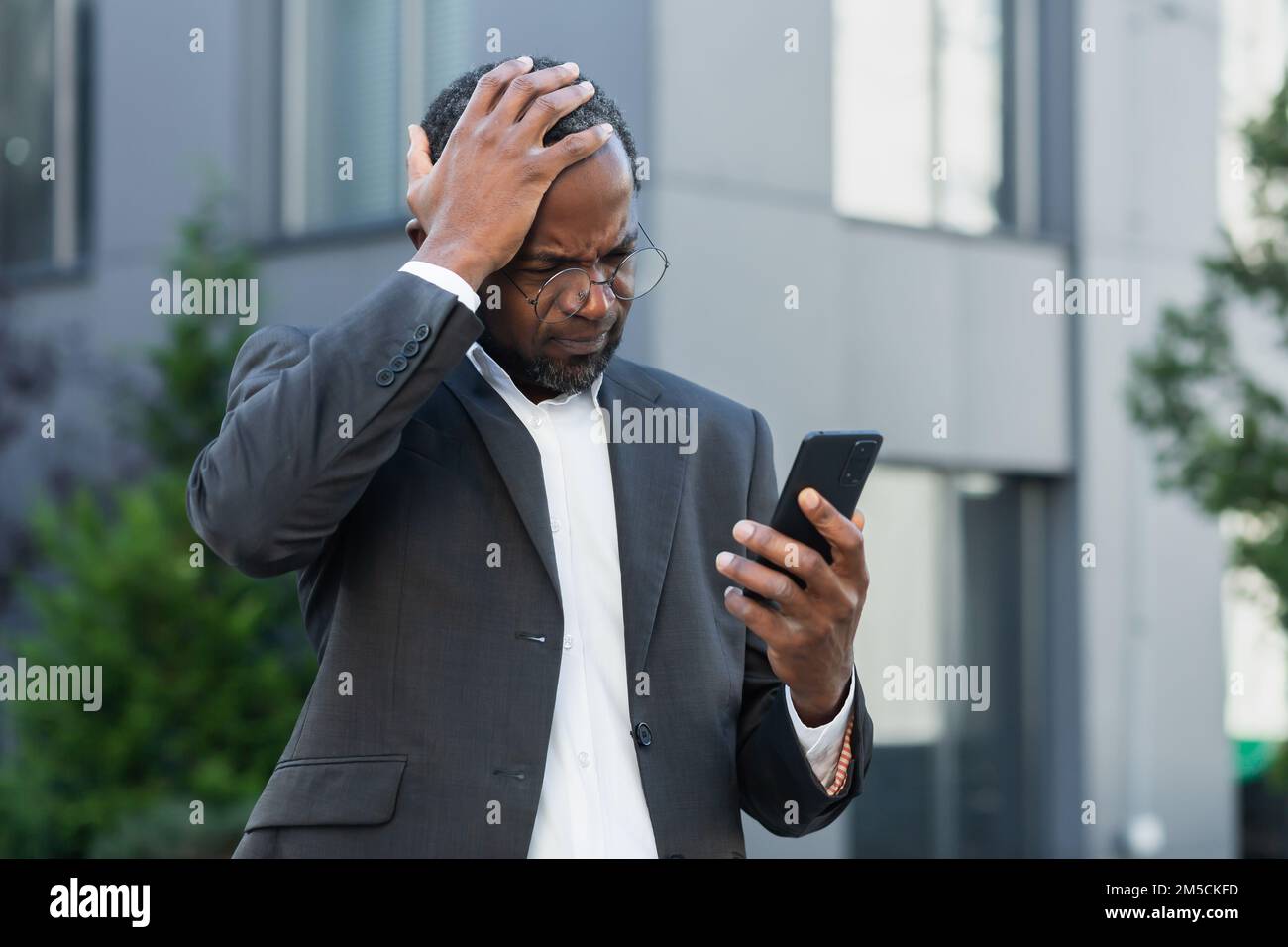 Mature senior african american boss reading bad news on phone ...