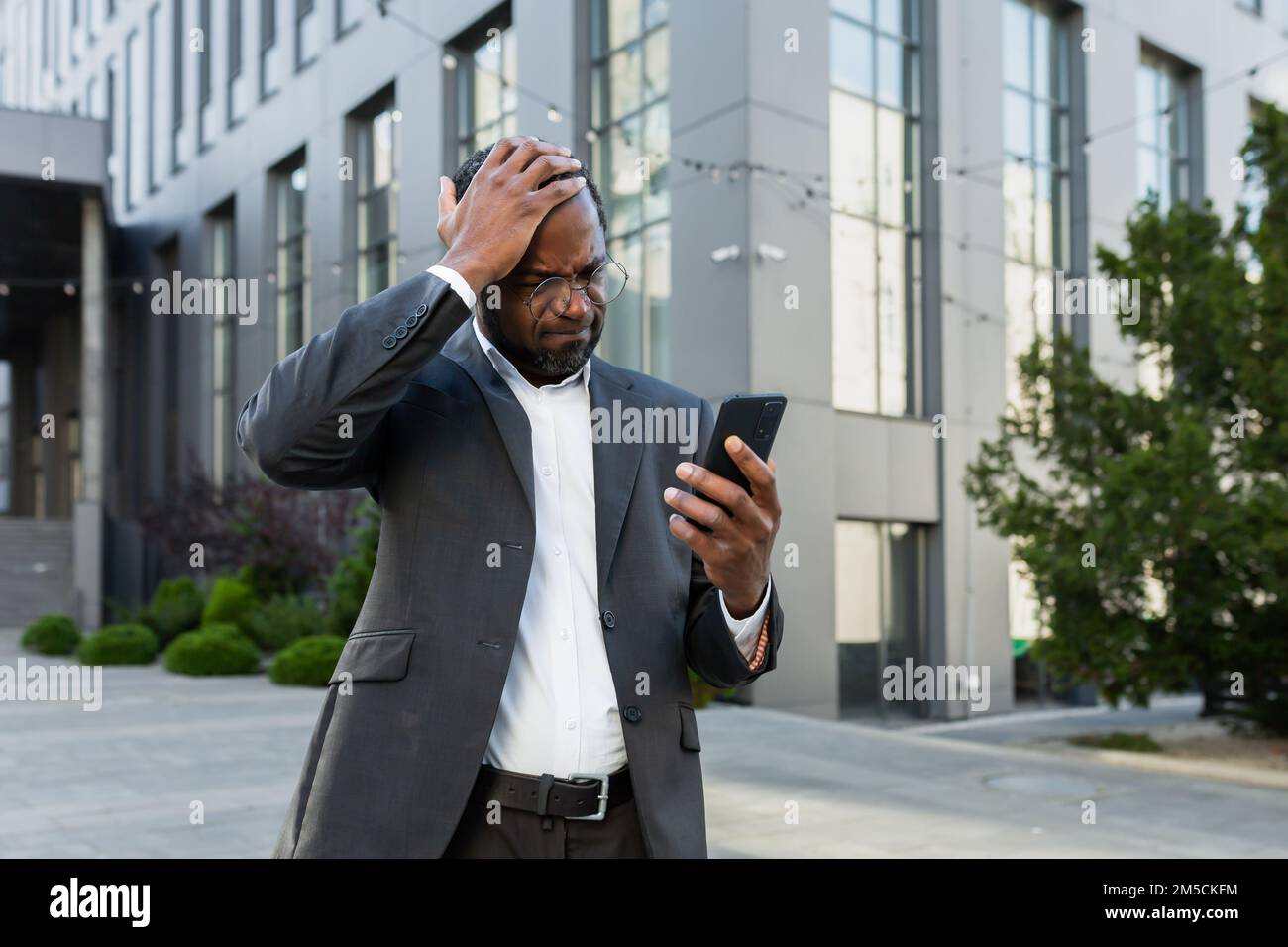 Mature senior african american boss reading bad news on phone ...