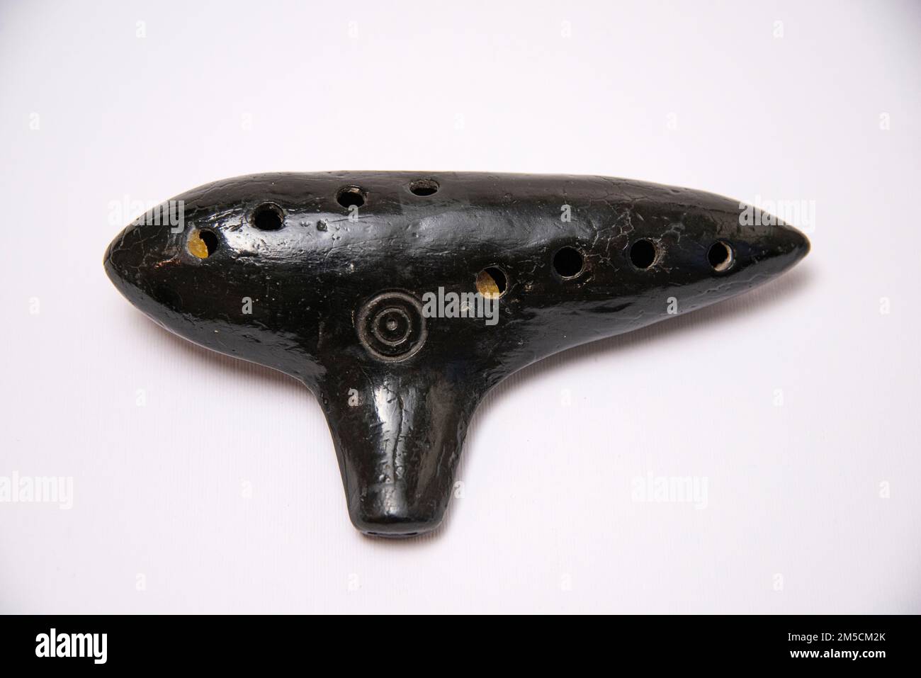 A closeup of an ocarina old wind musical instrument on a white ...
