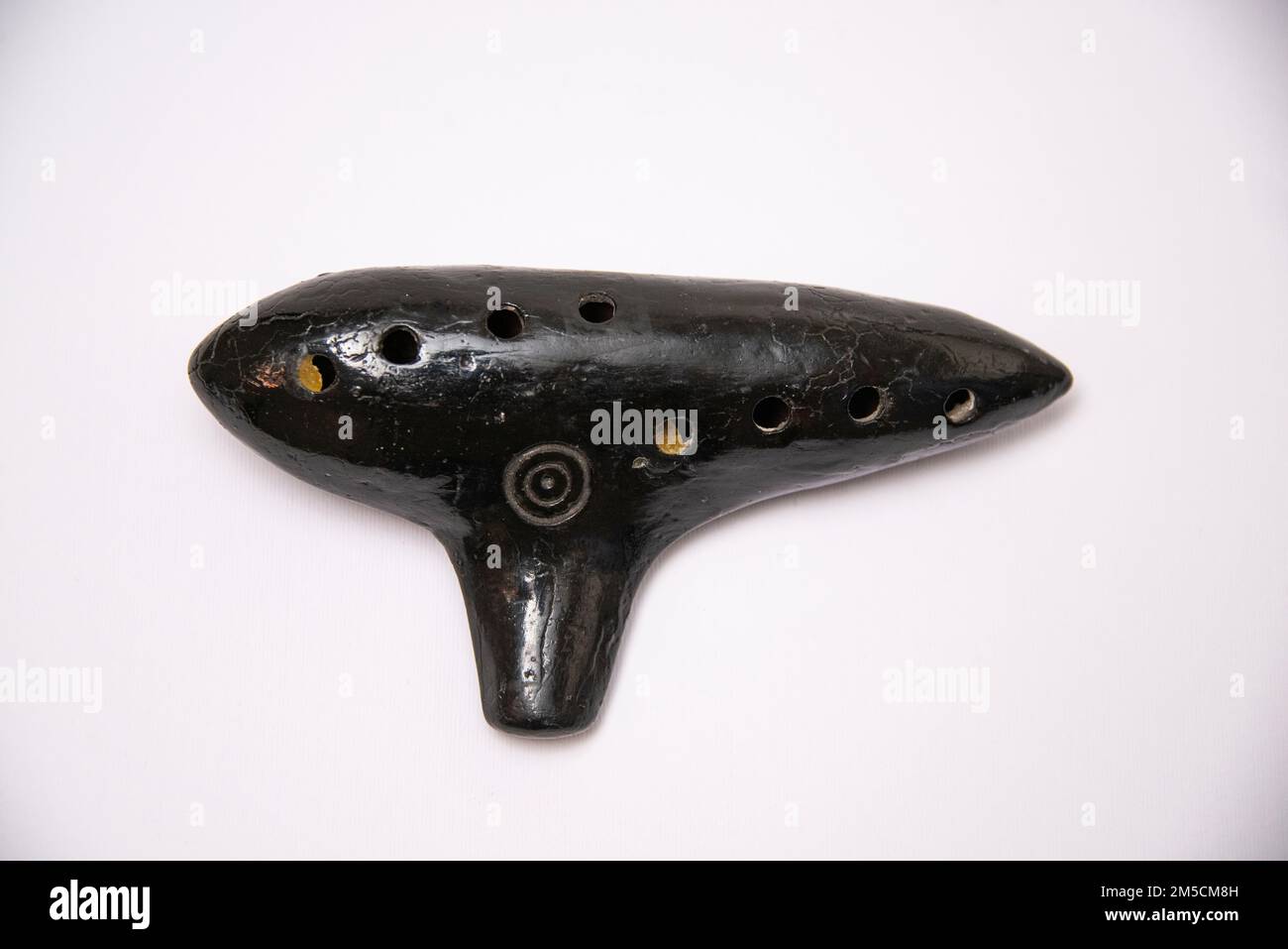 A closeup of an ocarina old wind musical instrument on a white ...