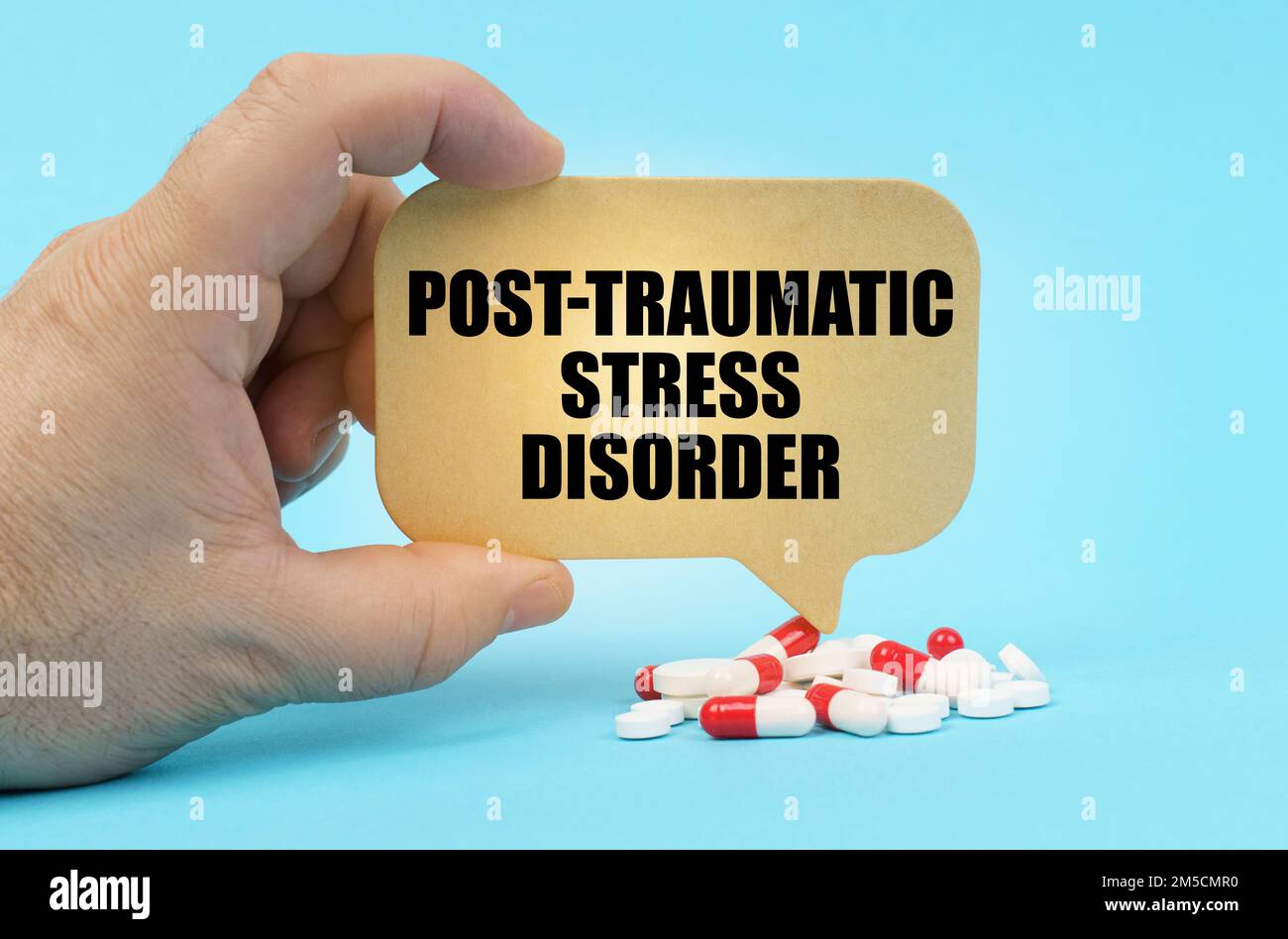 Medical concept. On a blue surface are pills in a persons hand, a sign ...