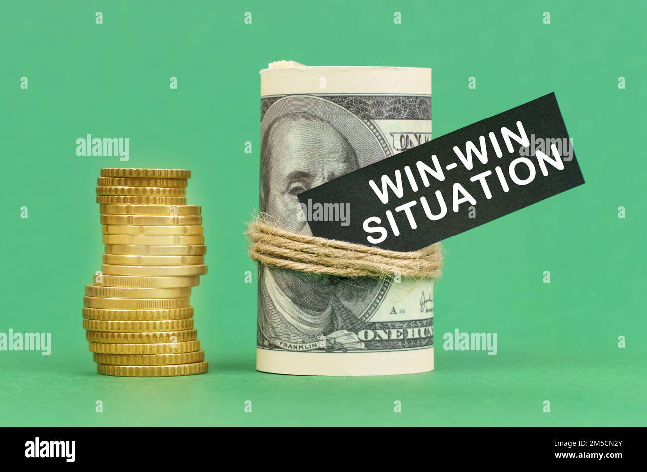 Business concept. On a green surface are coins and dollars in a bundle ...