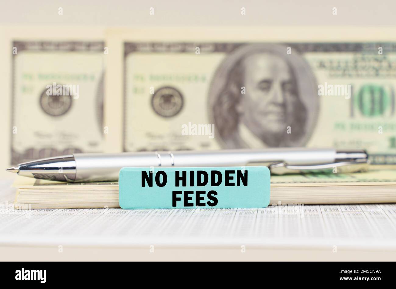 Business concept. On the dollars are a pen and a sign with the ...