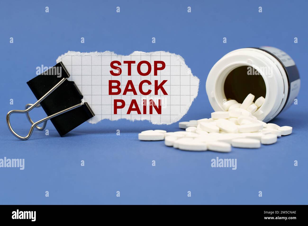 Medicine concept. On the blue surface lies a jar of pills and a clip ...