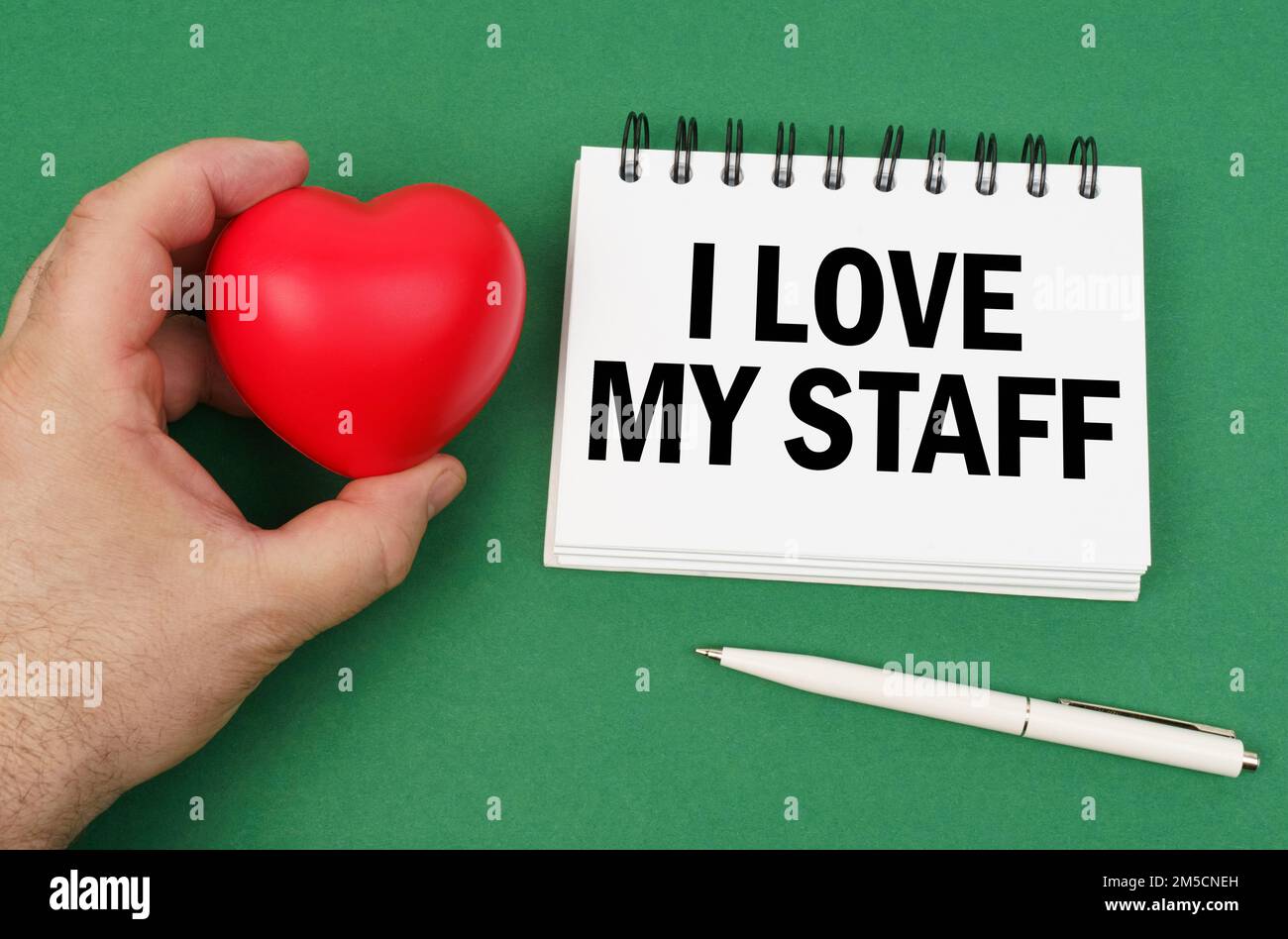 On the green surface are a pen, a notepad with the inscription - I love ...