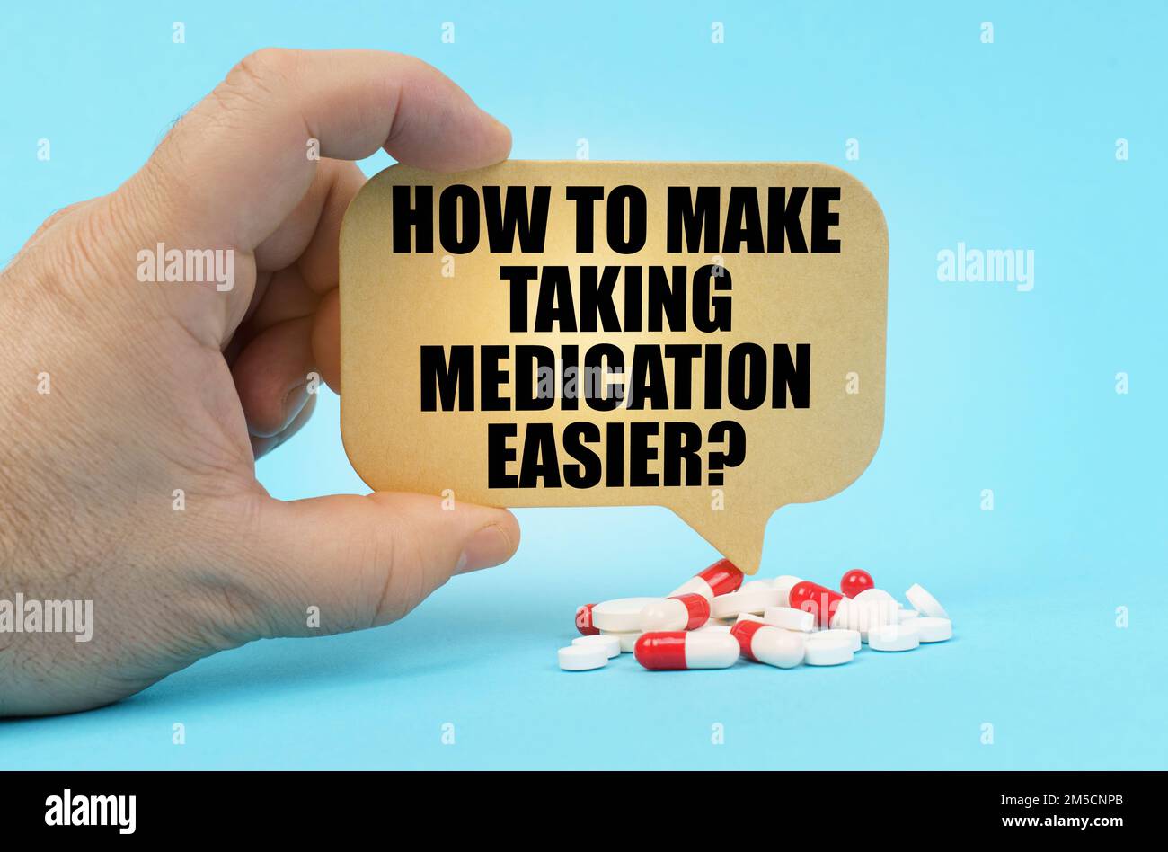 Medical concept. On a blue surface are pills in a persons hand, a sign ...