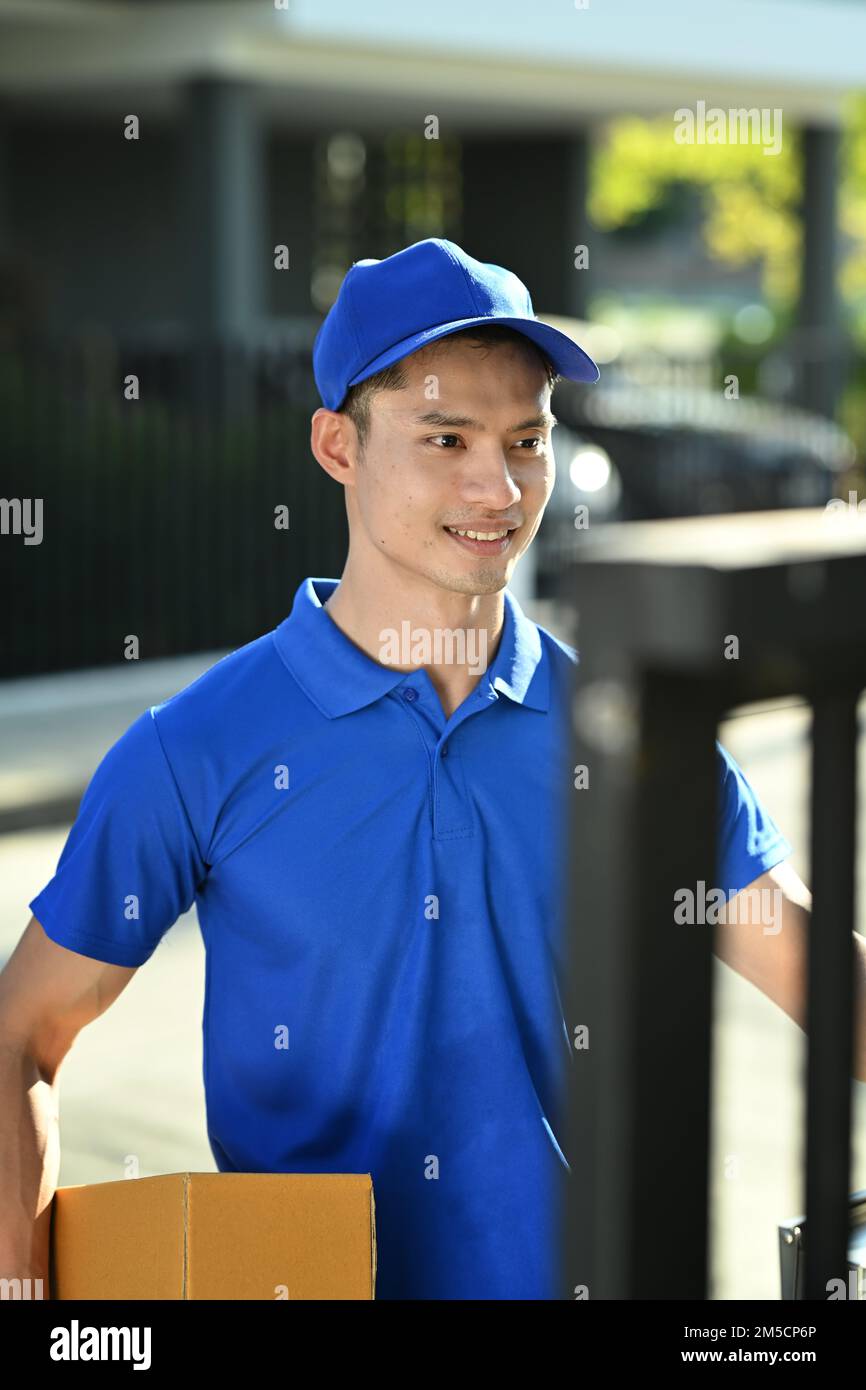 Delivery man holding cardboard box and ringing doorbell of customer ...
