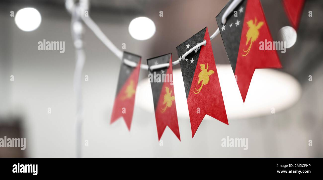 A garland of Papua New Guinea national flags on an abstract blurred ...