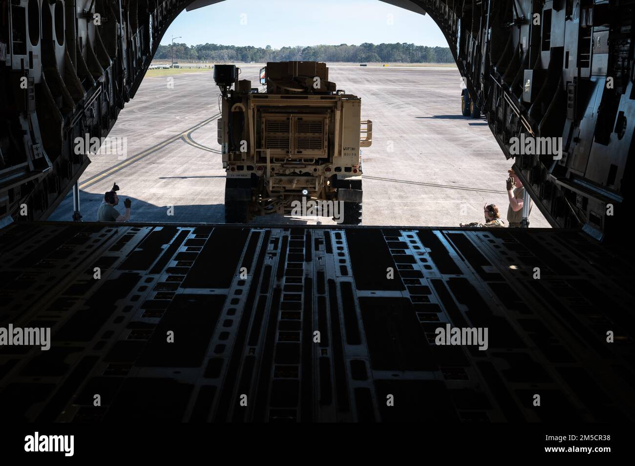 EAGLE team members guide an all-terrain vehicle onto a C-17 Globemaster ...